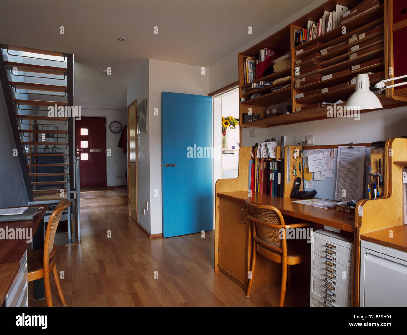 Shelving above desk and small chair in study area in modern hall with ...