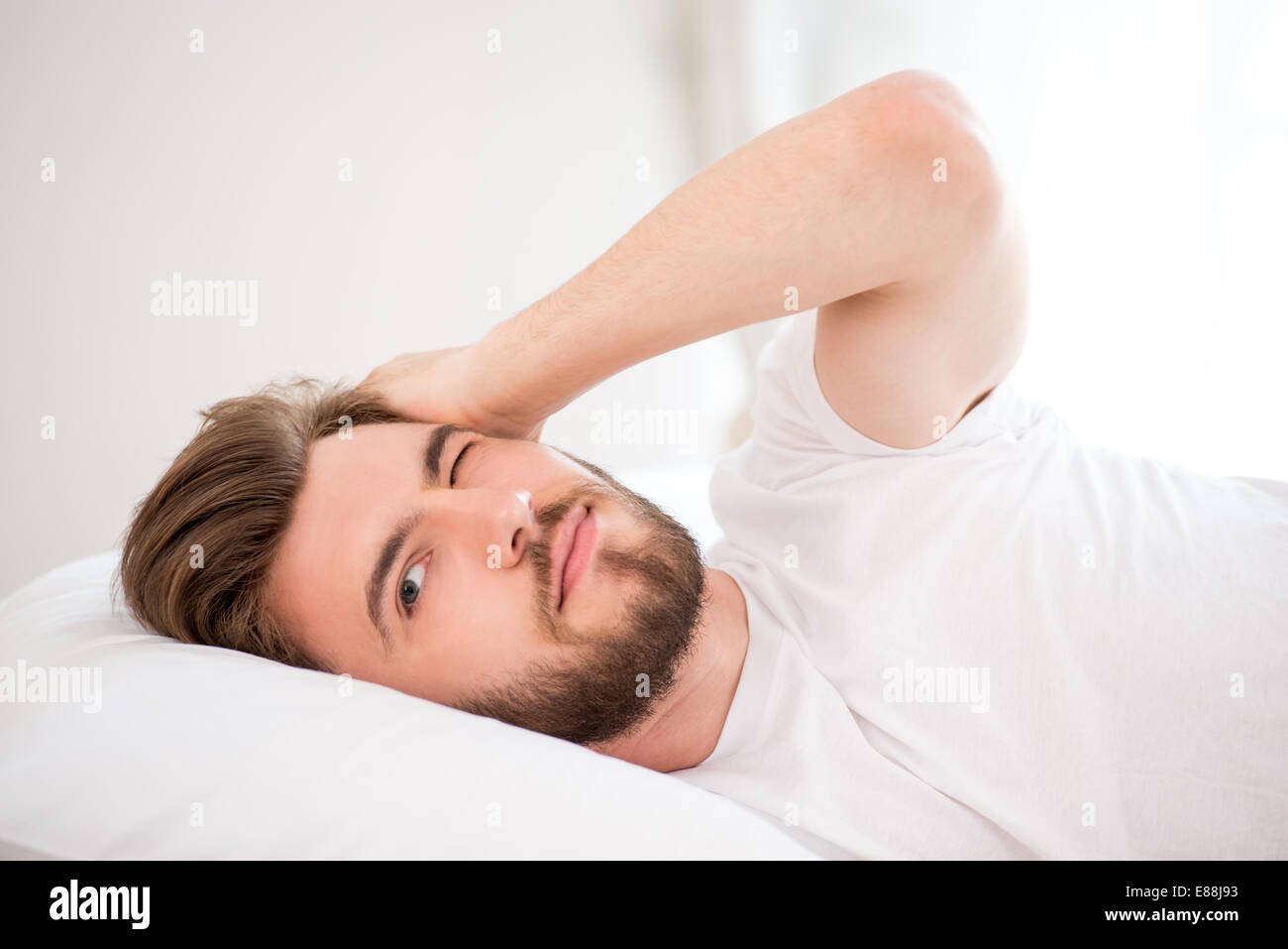 Young man waking up Stock Photo - Alamy