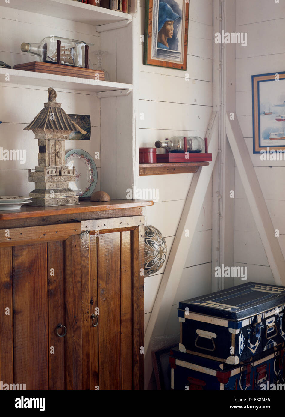 Ornate chest beside shelves and cupboard in corner of Caribbean hut ...