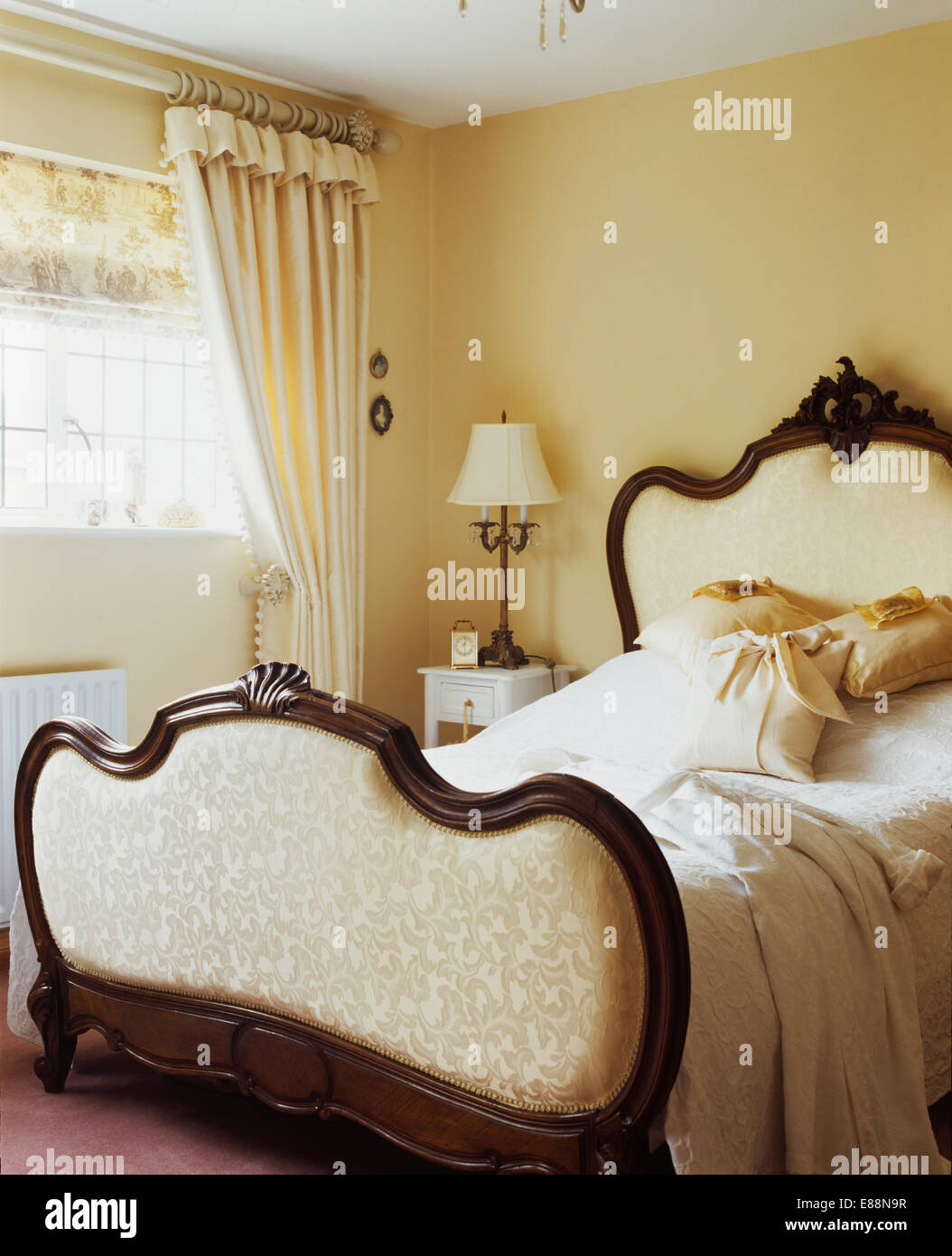 French-style cream upholstered bed in traditional cream bedroom Stock ...