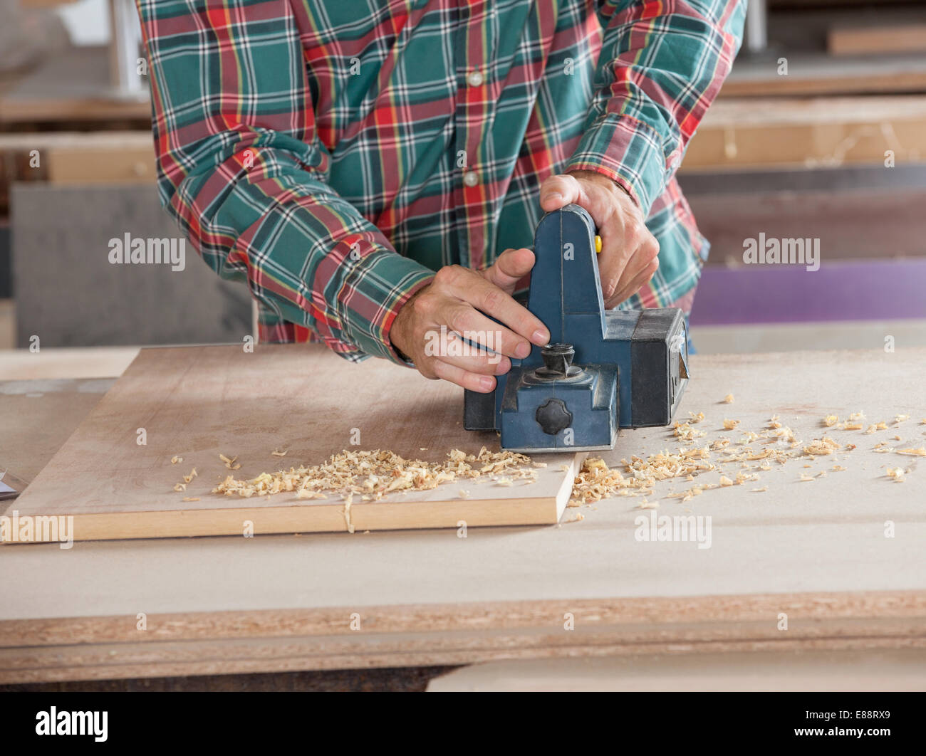 Carpenter Using Electric Planer On Wooden Plank Stock Photo - Alamy