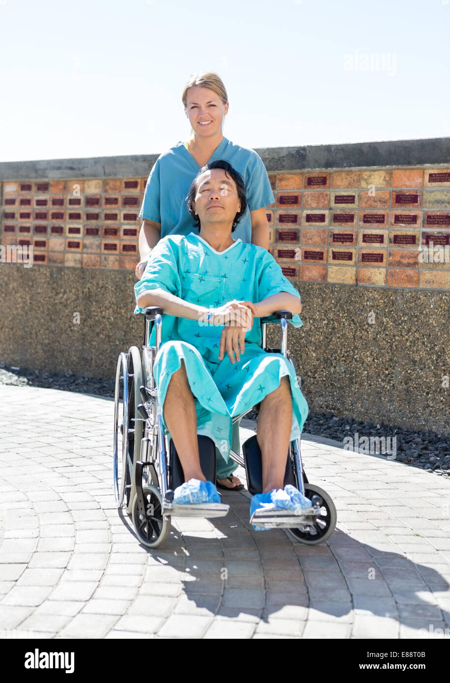 Nurse Pushing Relaxed Patient On Wheelchair At Courtyard Stock Photo ...