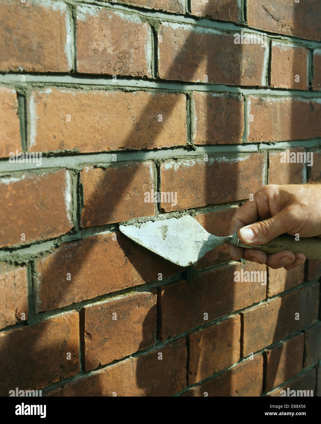 Close-up of hand using trowel to repoint brick wall Stock Photo - Alamy
