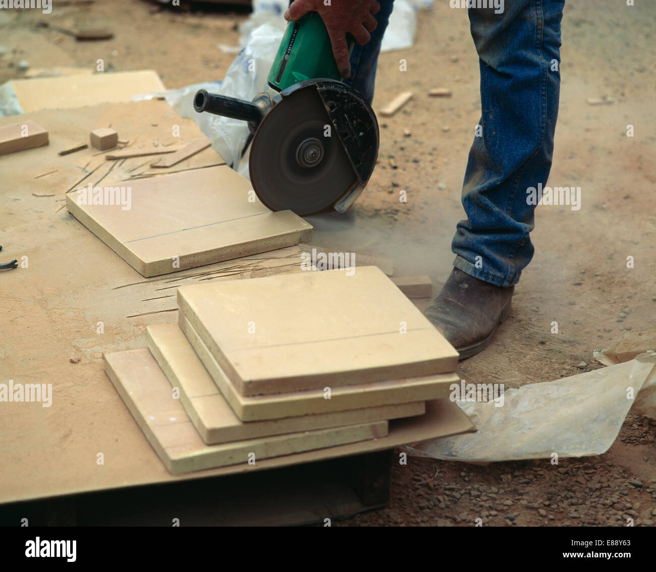Close-up of man using cutter to cut floor tiles Stock Photo - Alamy