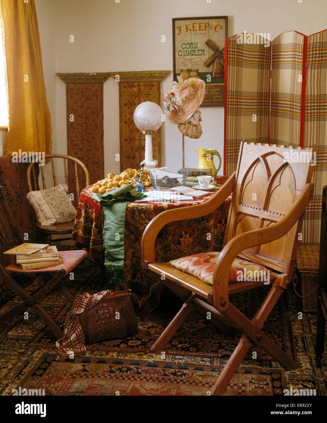 Antique chair and small table with richly patterned cloth in front of ...