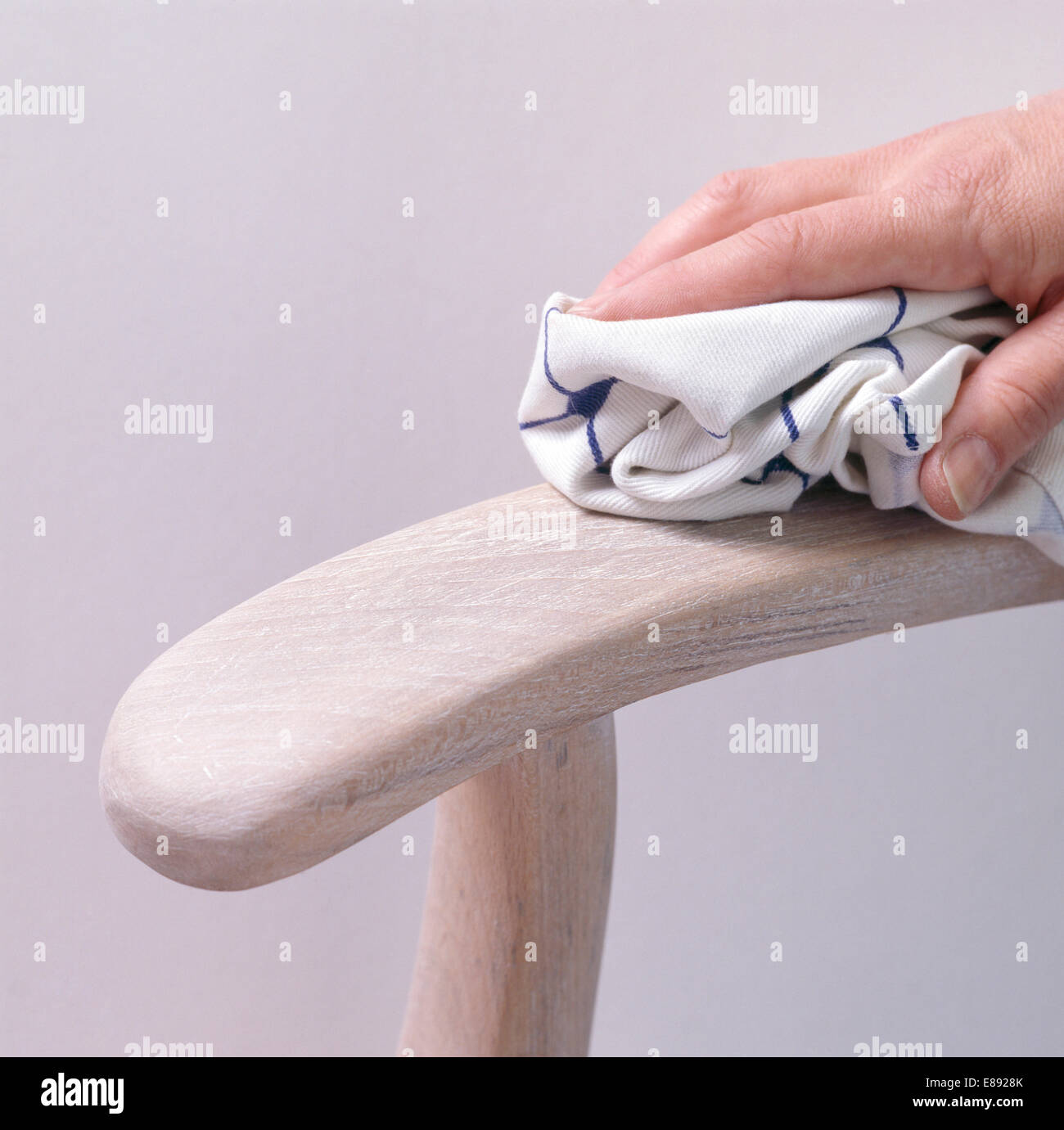 Close-up of hand using cloth to rub down wooden chair after applying ...