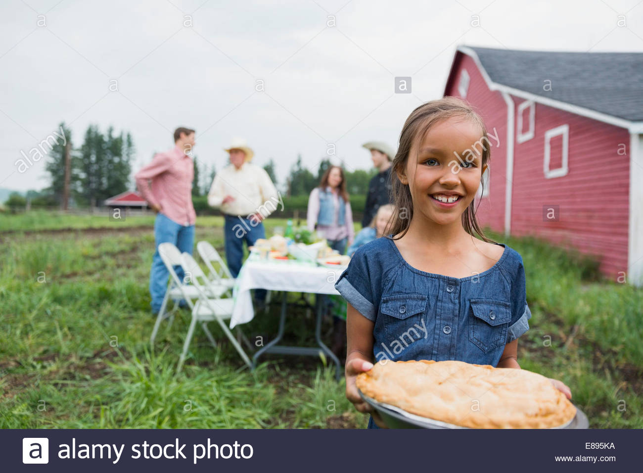 Smiling girl carrying pie outside barn Stock Photo - Alamy