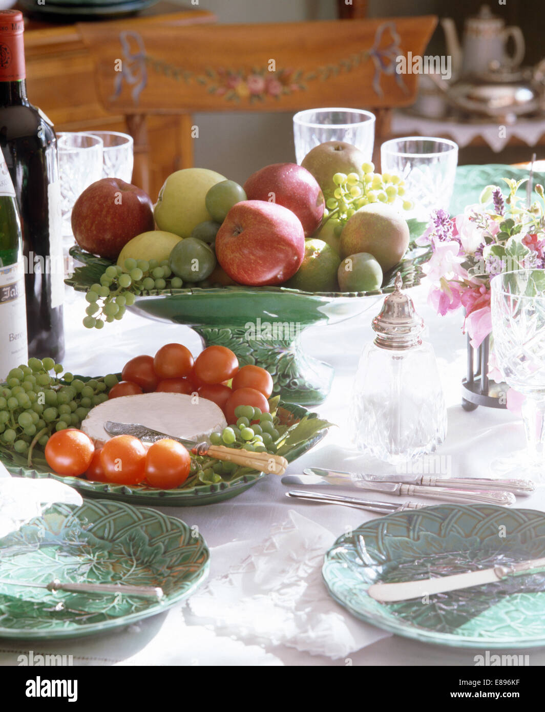 Still-Life of table setting with green cabbage plates beside apples on ...