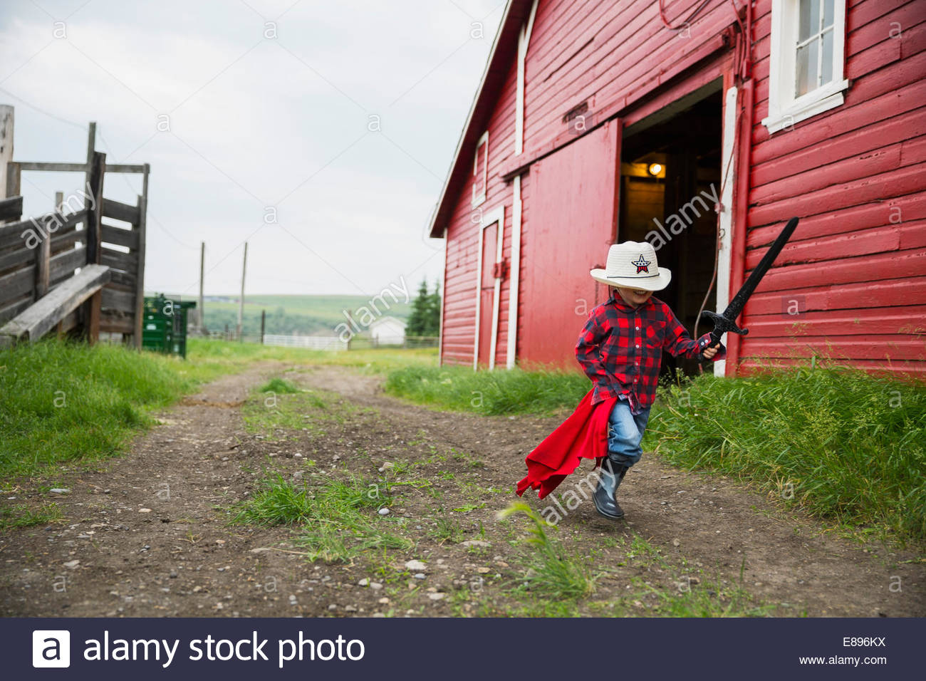 Boy with sword running outside barn Stock Photo - Alamy