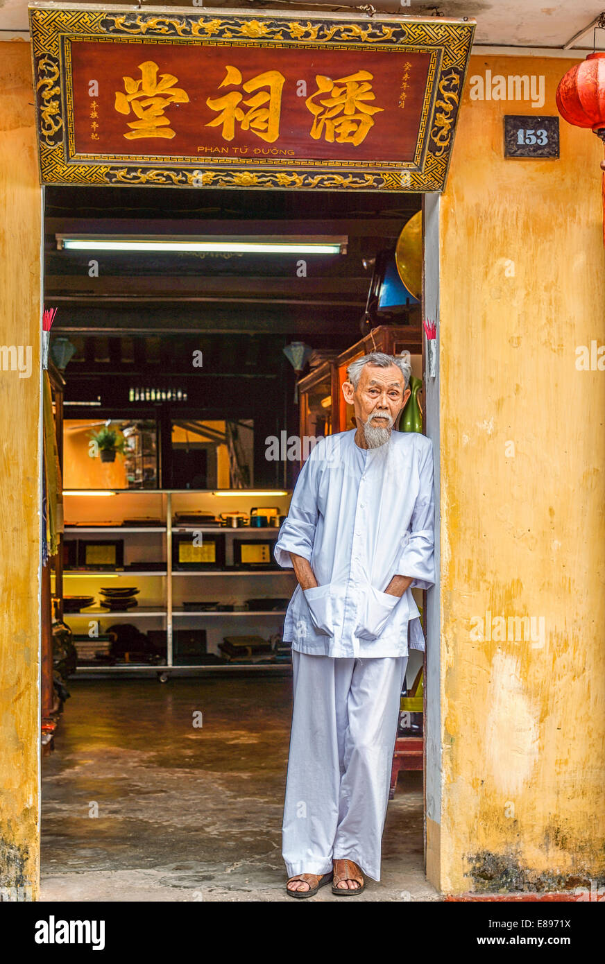 Traditional dressed older shop keeper in doorway Stock Photo - Alamy
