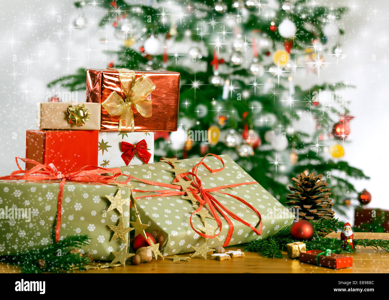many gifts on a table and Christmas tree with glittering background ...