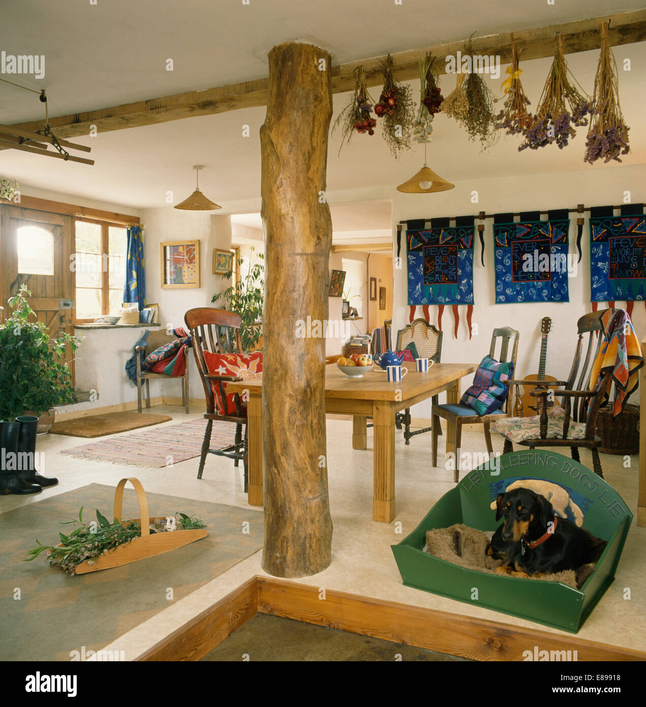 Rustic upright beam in eighties cottage dining room with dog in basket ...