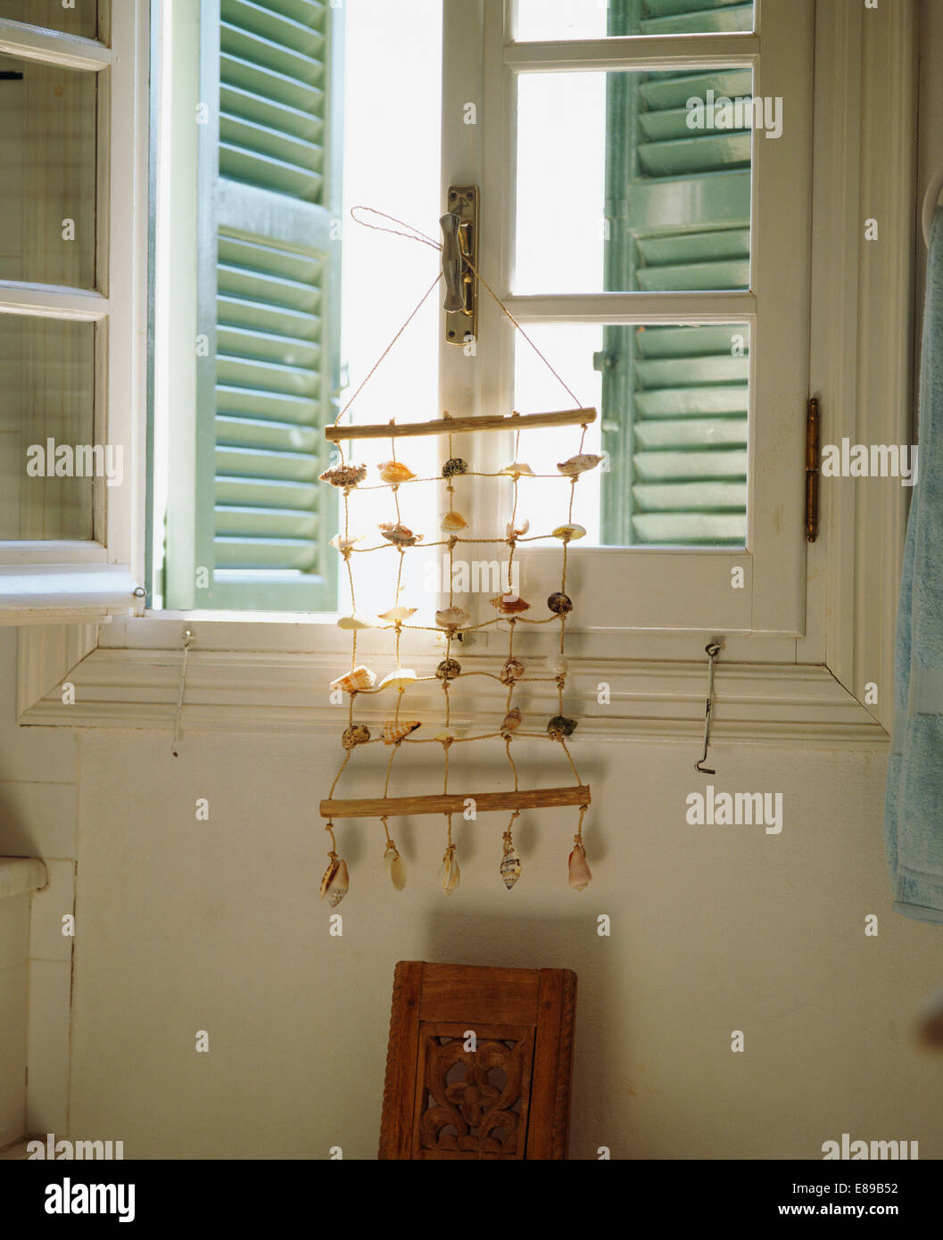 Close-up of window with mobile made from seashells Stock Photo - Alamy