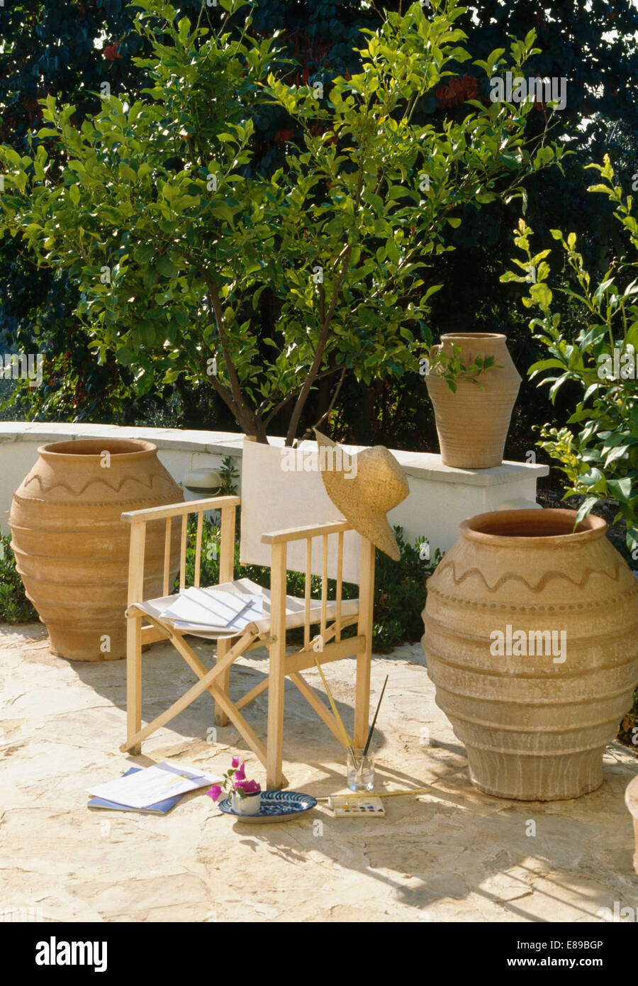 Large terracotta Pithoi pots on either side of canvas director's chair ...