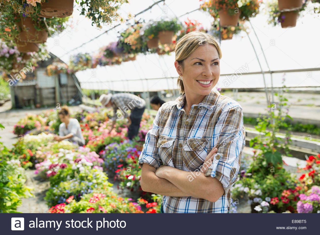 Smiling worker in plant nursery greenhouse Stock Photo - Alamy