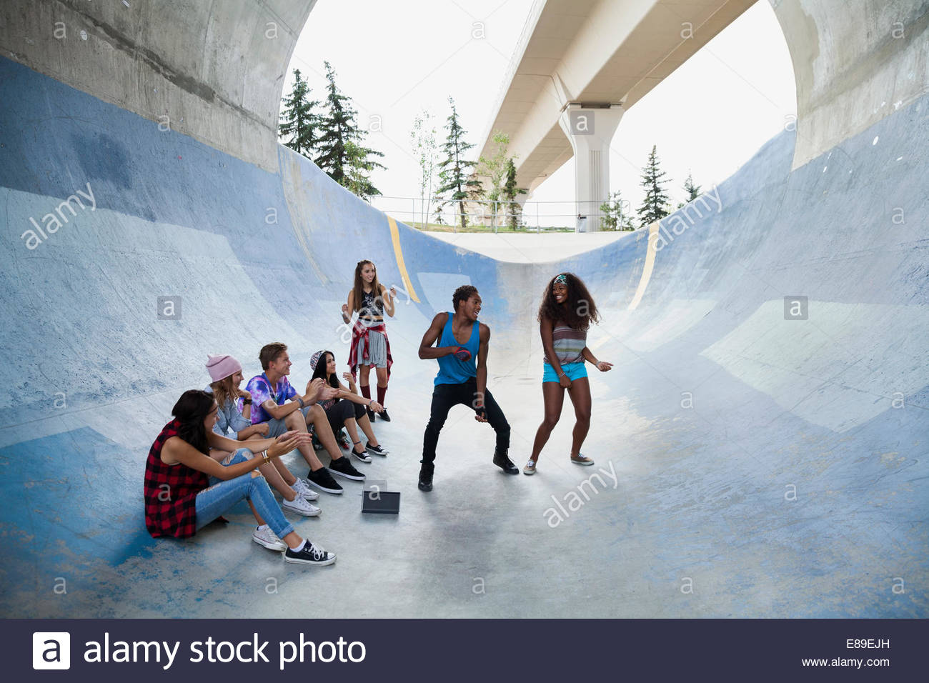 Teenagers dancing on ramp at skateboard park Stock Photo - Alamy