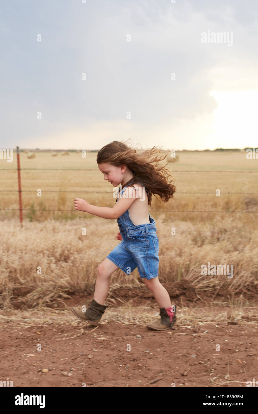 Girl running along country road Stock Photo - Alamy