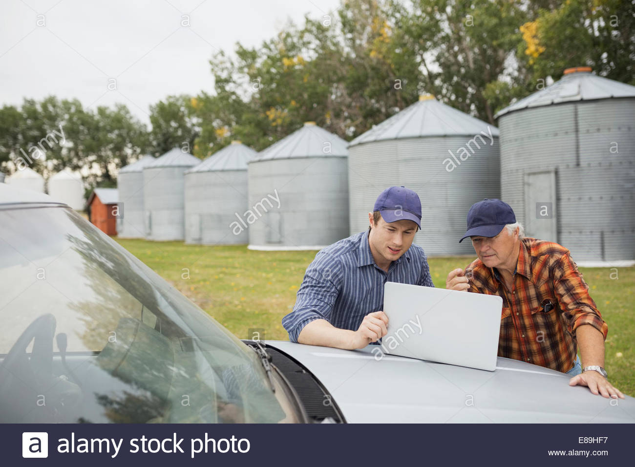 Farmers using laptop on truck on farm Stock Photo - Alamy