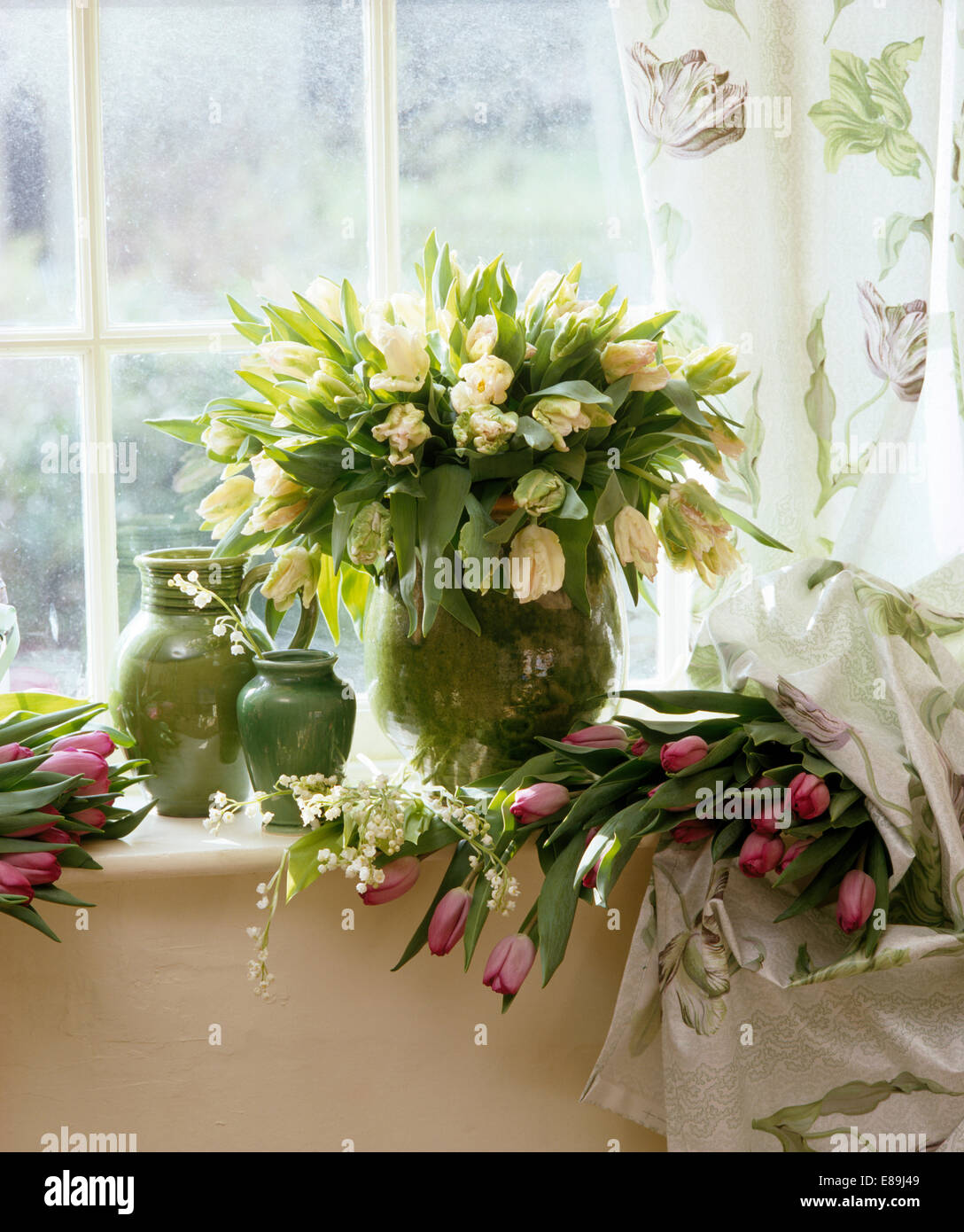 Still-Life of pale pink tulips in green vase on windowsill with sheaf ...
