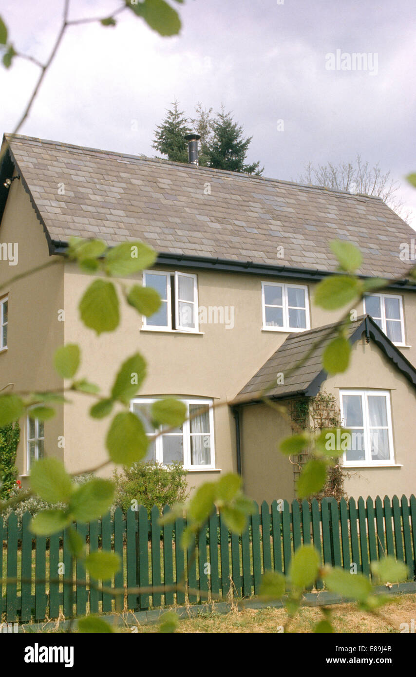 Green picket fence in front of newly painted cottage Stock Photo - Alamy