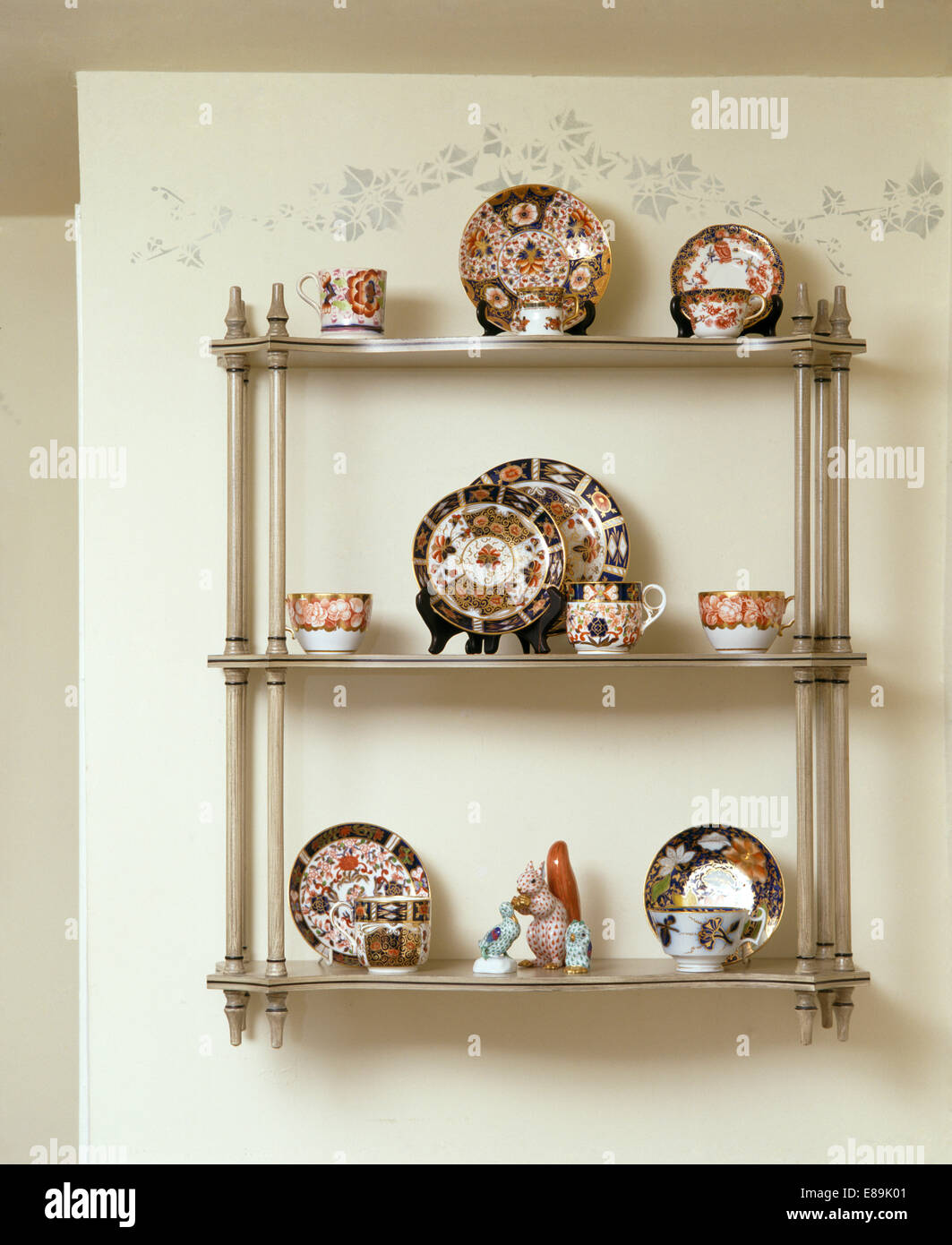 Close-up of collection of antique china on painted Victorian shelves ...