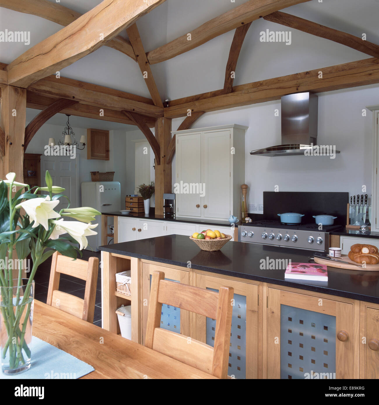 Granite-topped island unit with opaque glazed doors in country barn ...