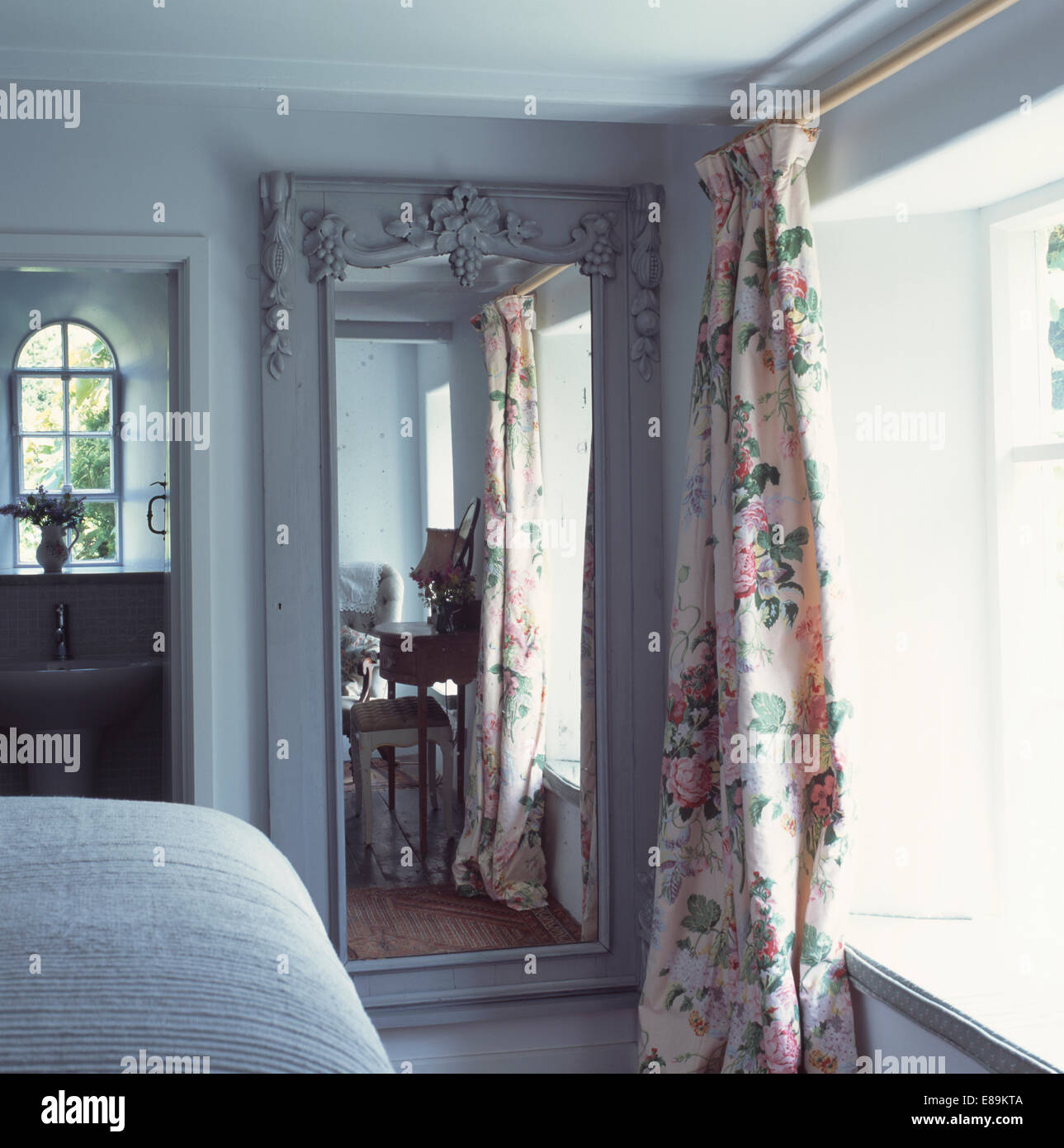 Large grey mirror with carved ornamental detail in country bedroom with ...
