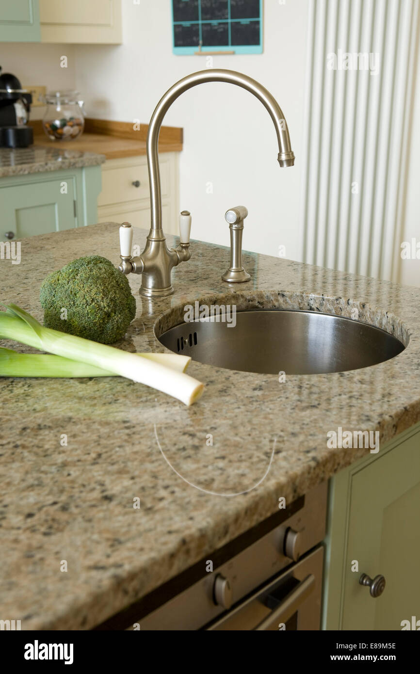Circular stainless steel sink set in granite worktop in modern kitchen ...