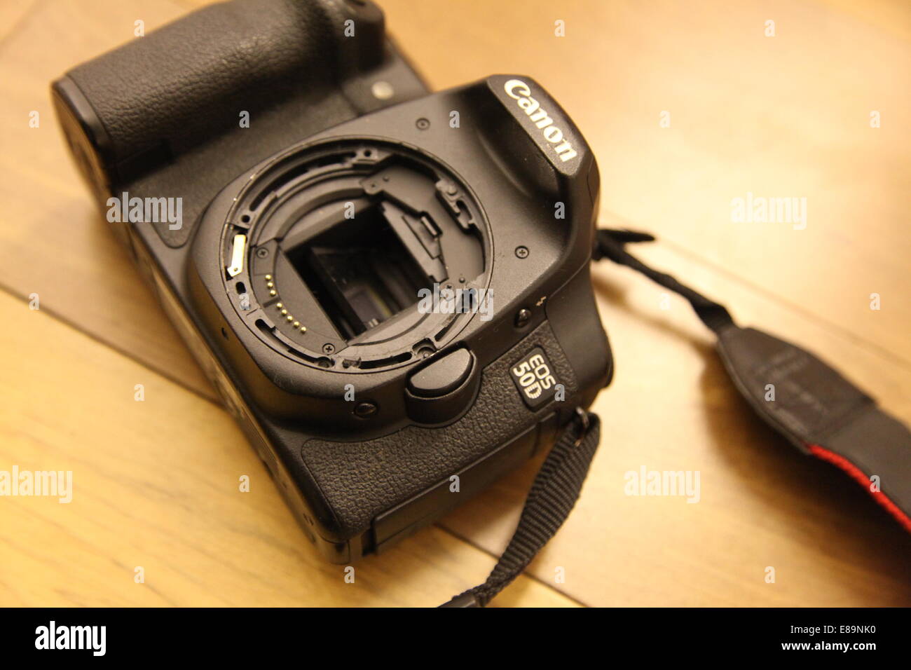 Parts of a broken Canon 50d DSLR camera laying on a wooden floor Stock ...