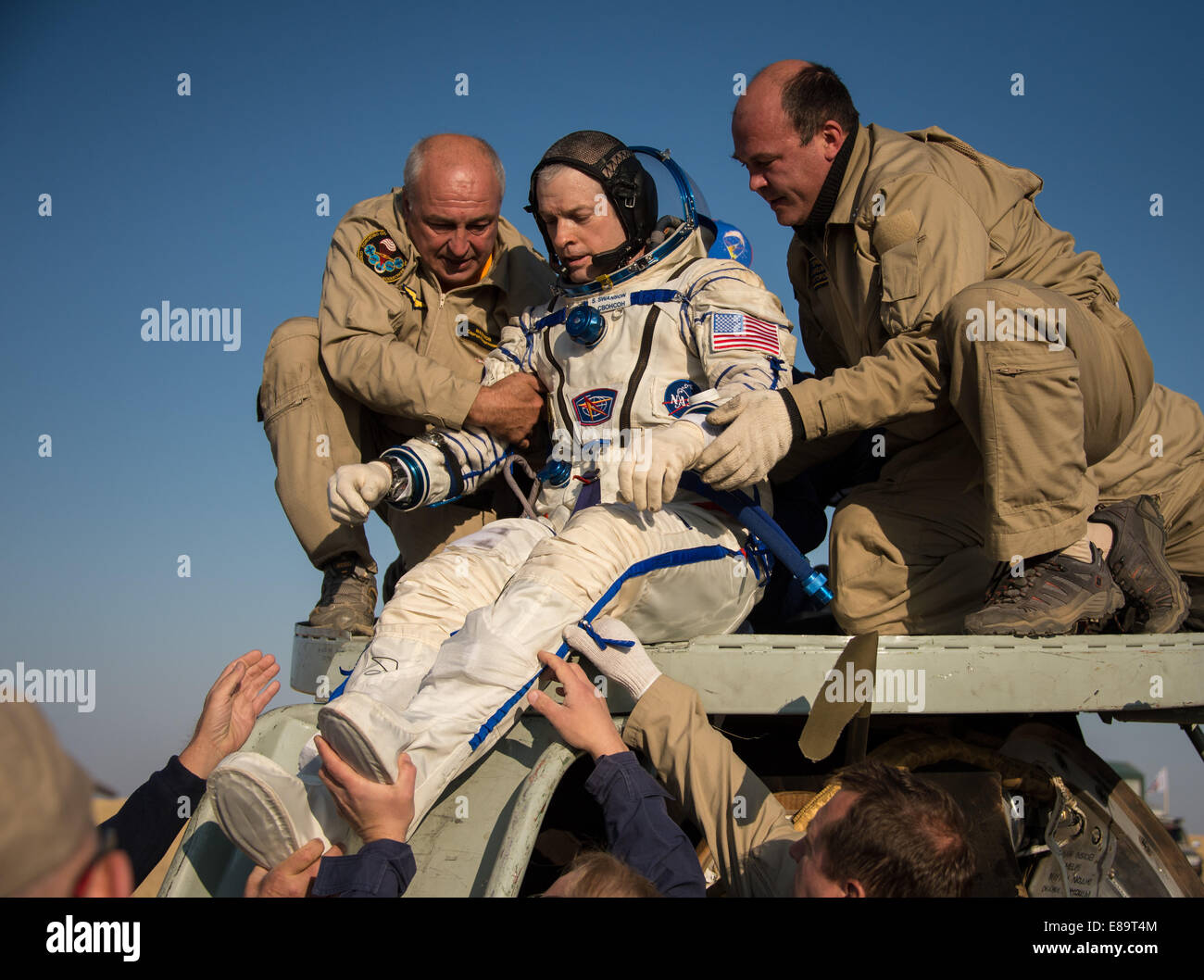Expedition 40 Commander Steve Swanson of NASA is helped out of the ...