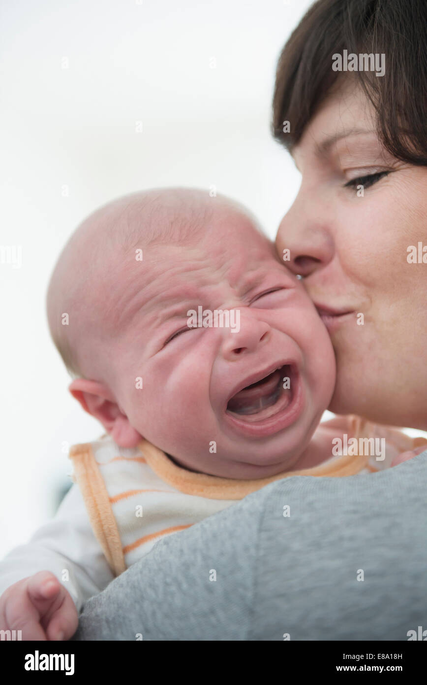 Mother holding her crying son, close up Stock Photo - Alamy