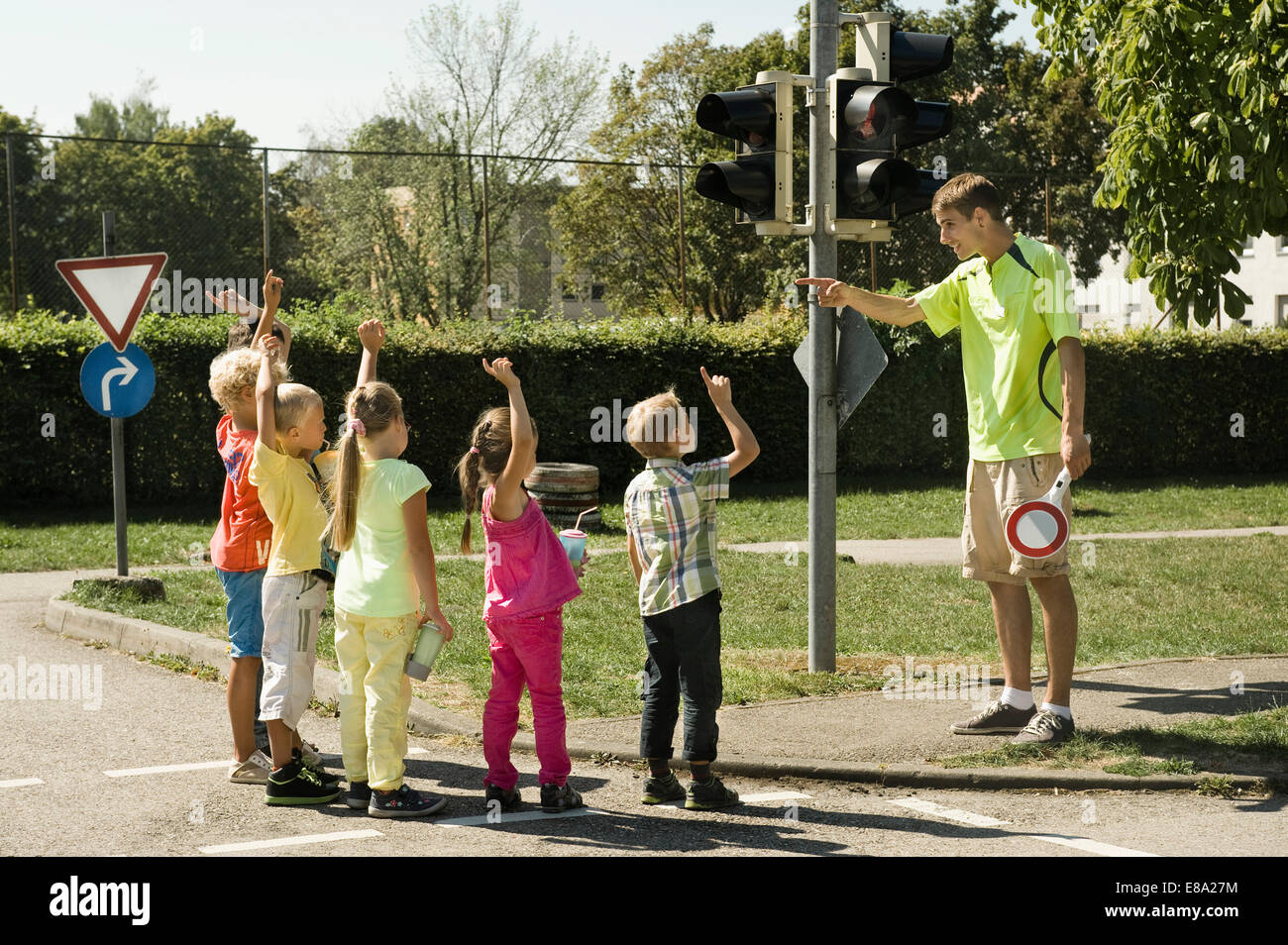 Tutor and children at traffic light on driver training area Stock Photo ...