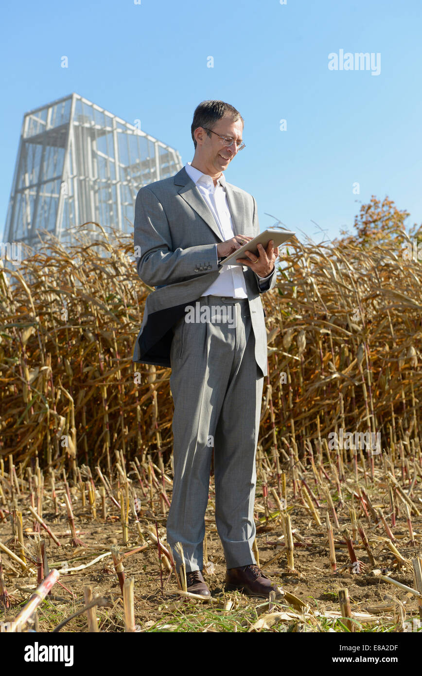 businessman with digital tablet in cornfield, geothermal power station ... businessman with digital tablet in cornfield, geothermal power station ...