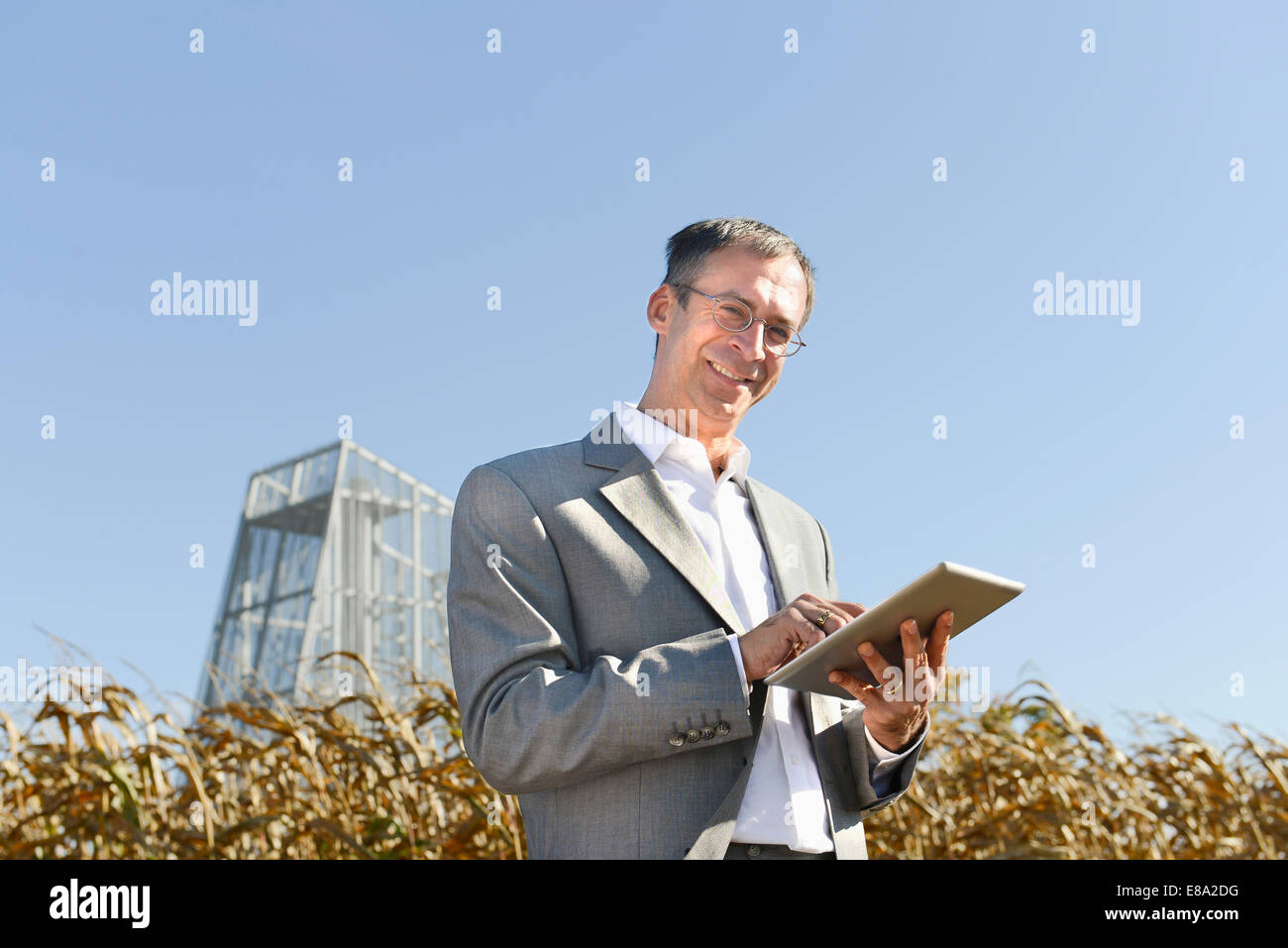 businessman with digital tablet in cornfield, geothermal power station ... businessman with digital tablet in cornfield, geothermal power station ...