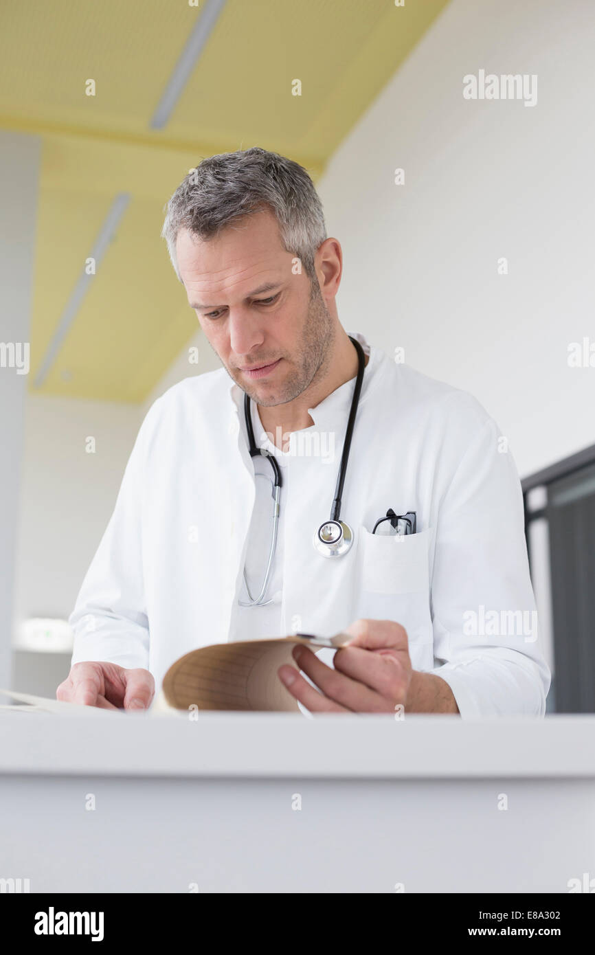 Doctor reading file Stock Photo - Alamy