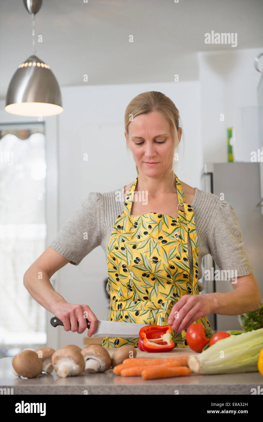 Woman cutting vegetables in kitchen Stock Photo - Alamy