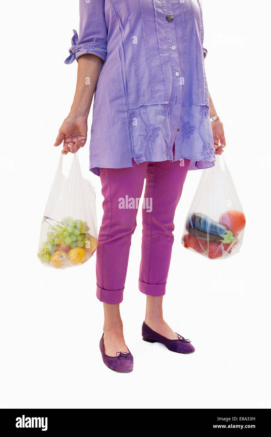 Senior woman holding fruits and vegetables in plastic bag Stock Photo ...