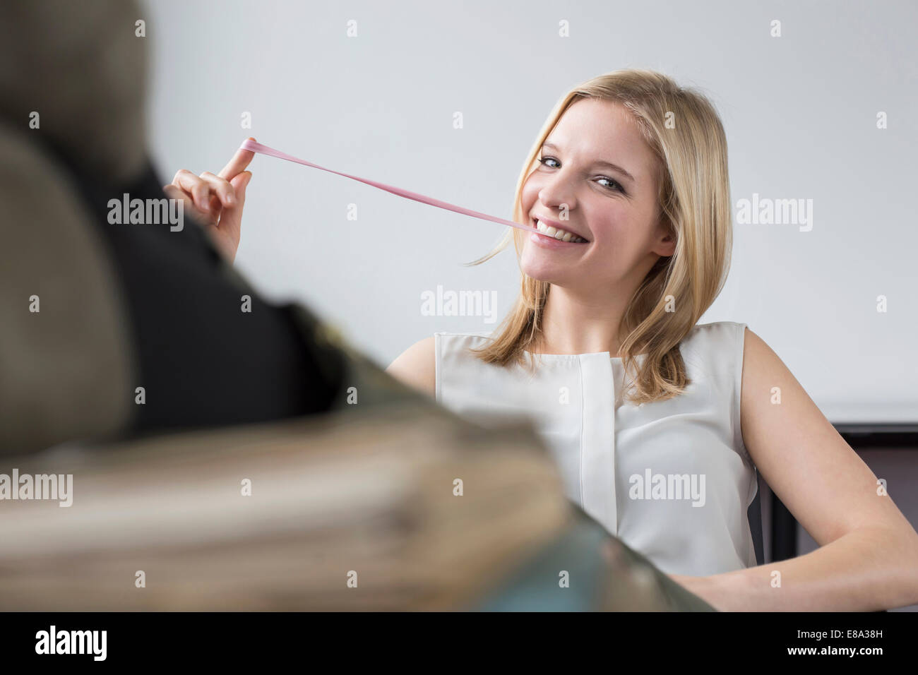 Portrait of businesswoman pulling chewing gum, smiling Stock Photo - Alamy
