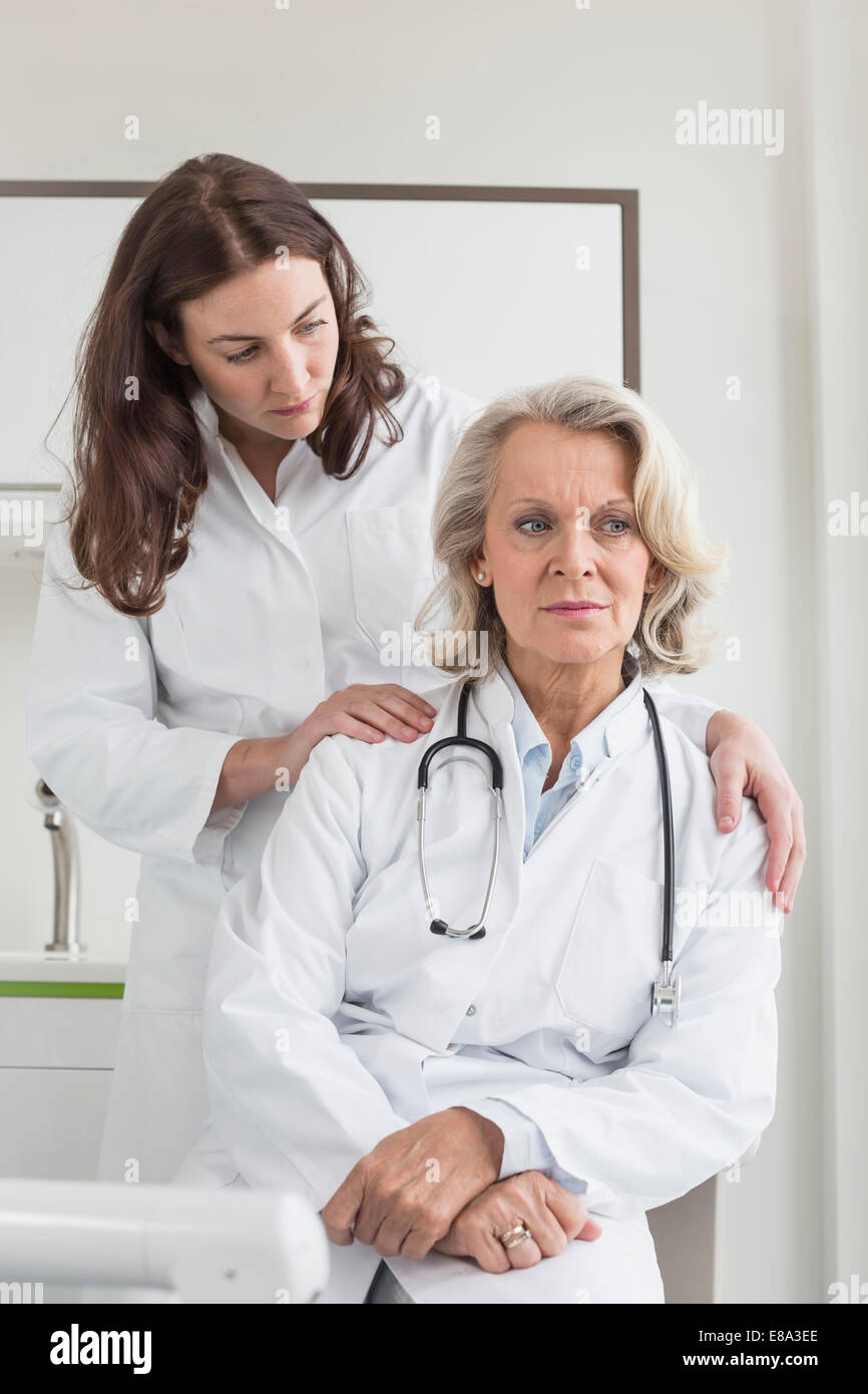 Female doctor consoling collegue Stock Photo - Alamy