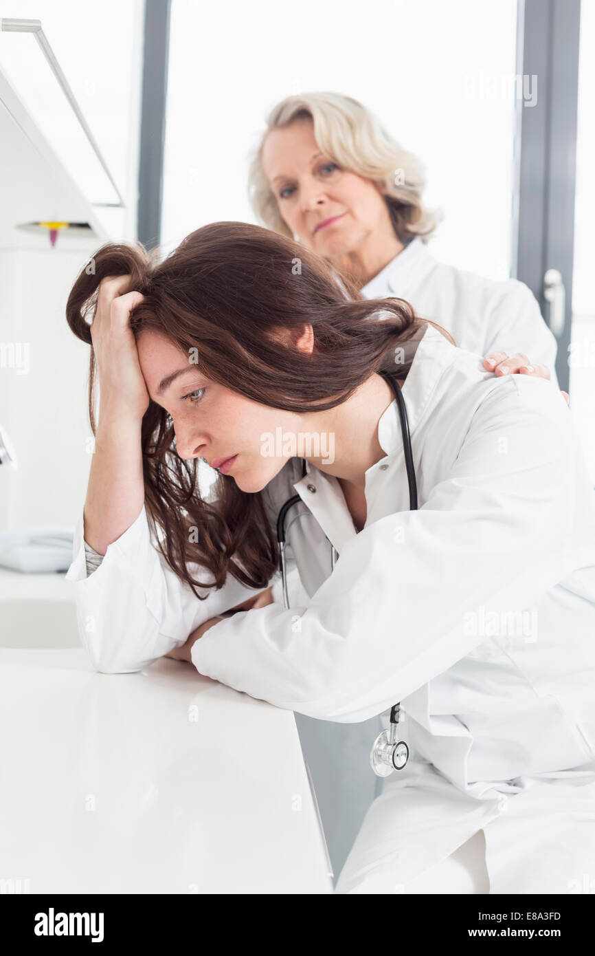 Female doctor consoling collegue Stock Photo - Alamy