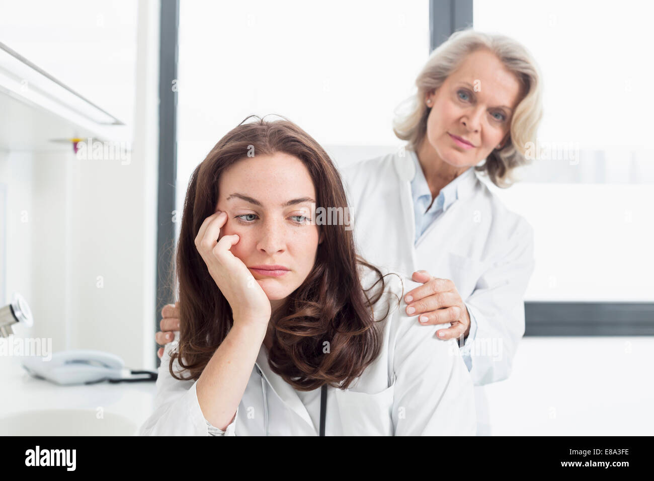 Female doctor consoling collegue Stock Photo - Alamy
