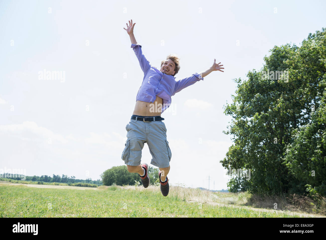 Mid adult man jumping Stock Photo - Alamy