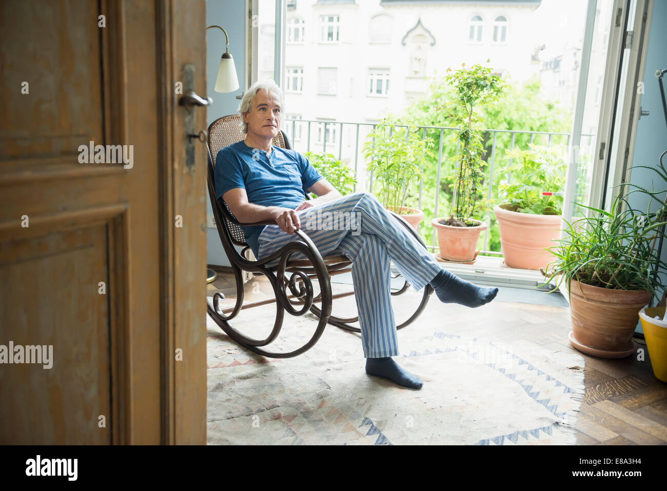 Mature man sitting in rocking chair Stock Photo - Alamy