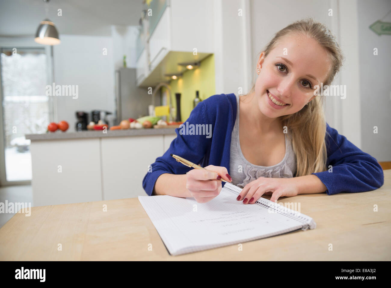 Portrait of teenage girl writing notes, smiling Stock Photo - Alamy