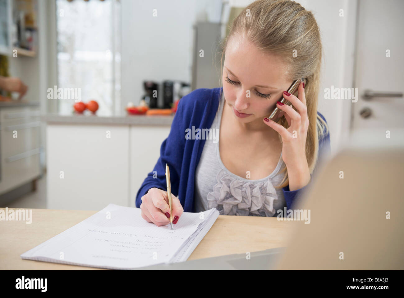Teenage girl talking on phone and writing notes Stock Photo - Alamy