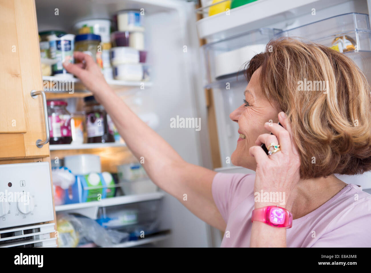 Senior woman infront of open refrigerator, smiling Stock Photo - Alamy