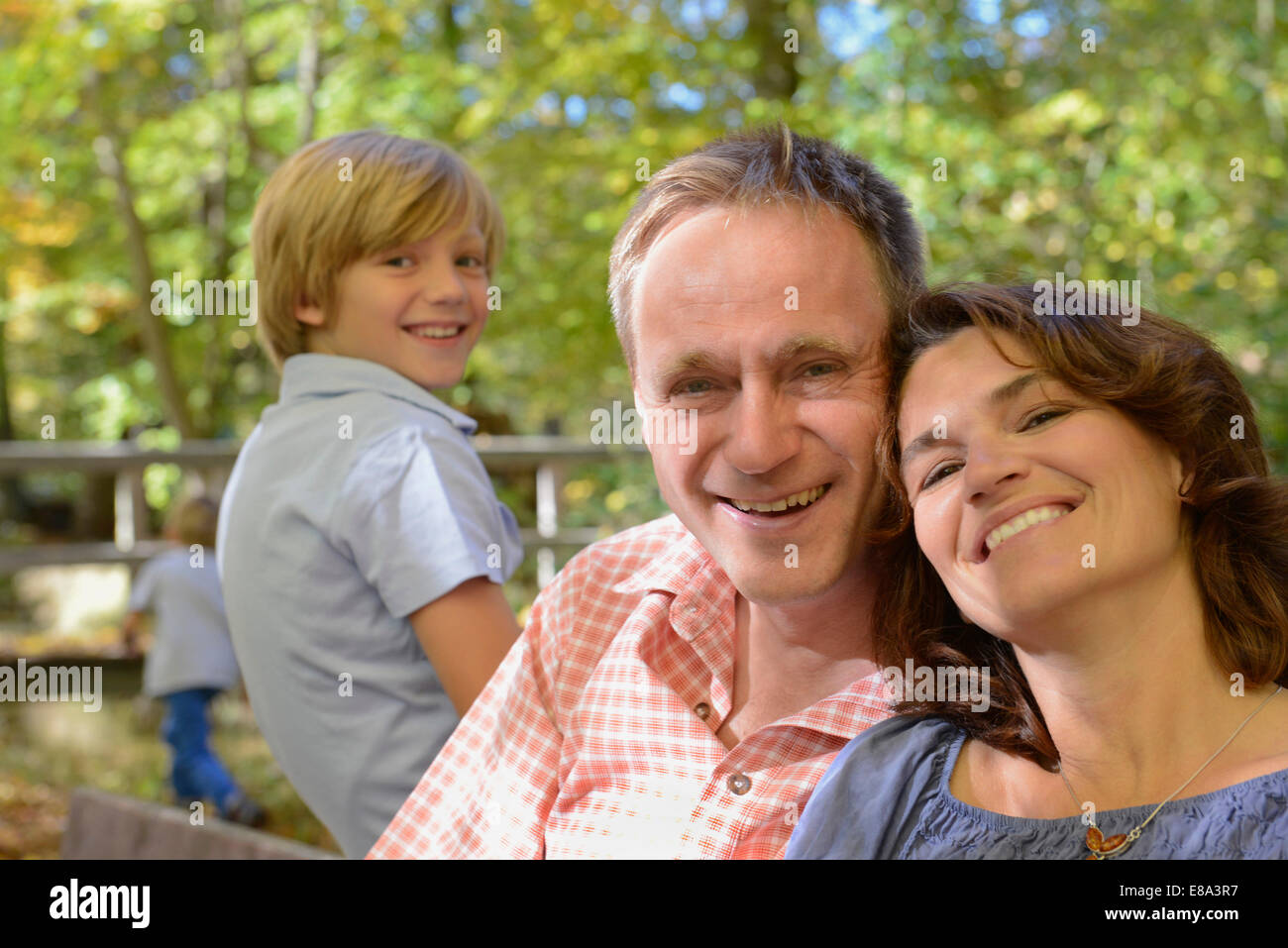 Family sitting on bench, smiling, portrait, Bavaria, Germany Stock ...