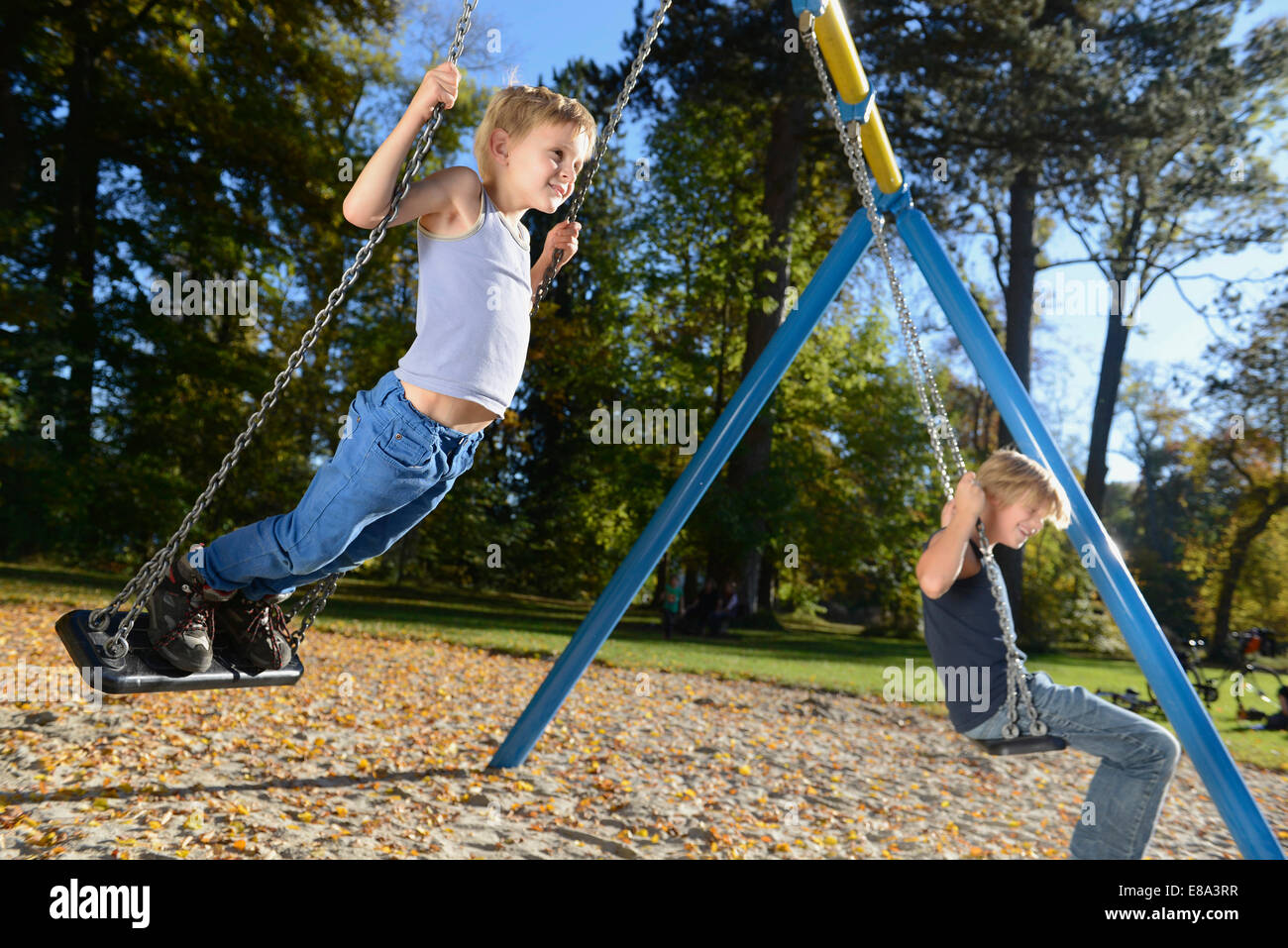 Boys swinging on swing in playground, Bavaria, Germany Stock Photo - Alamy