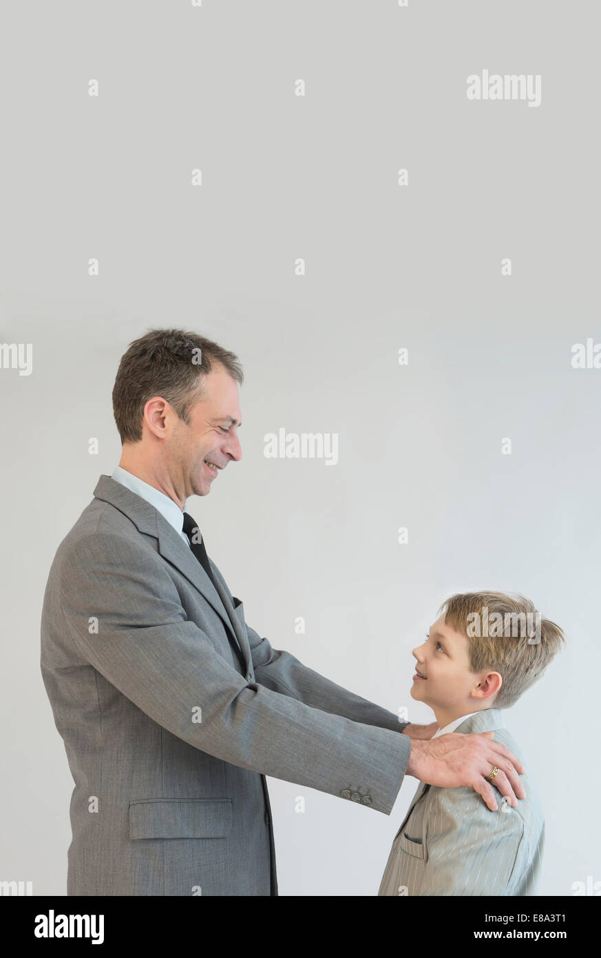 Father talking to son with hands on his shoulder, smiling Stock Photo ...