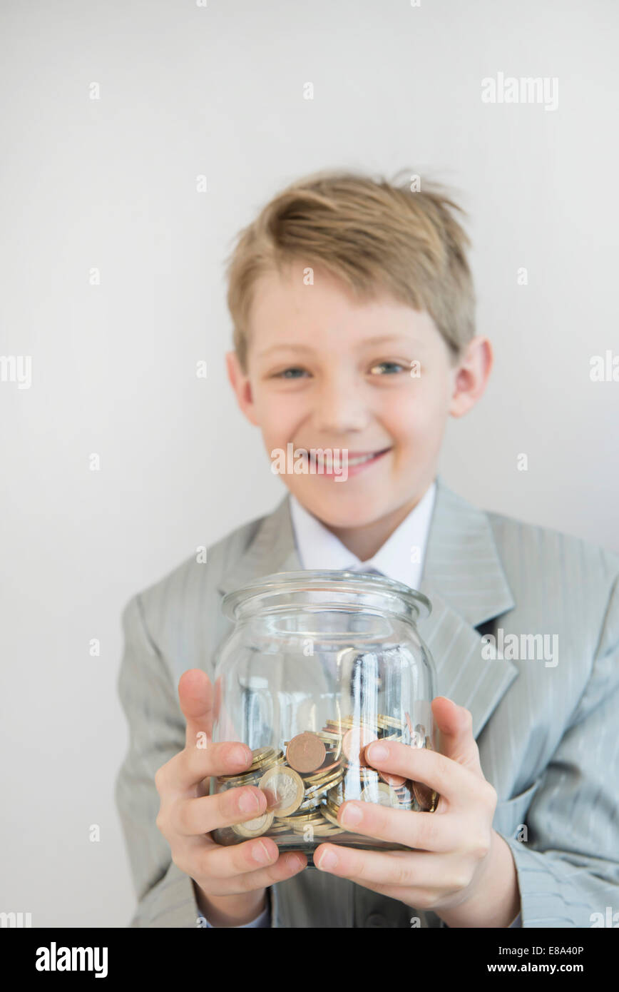 Boy holding piggy bank, smiling, portrait Stock Photo - Alamy